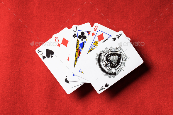 top view of red poker table and unfolded playing cards with different ...