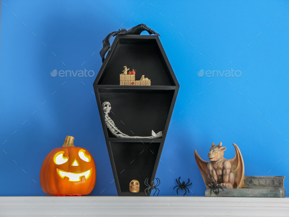 Skeleton and skull Halloween decoration in coffin shelf next to a ...
