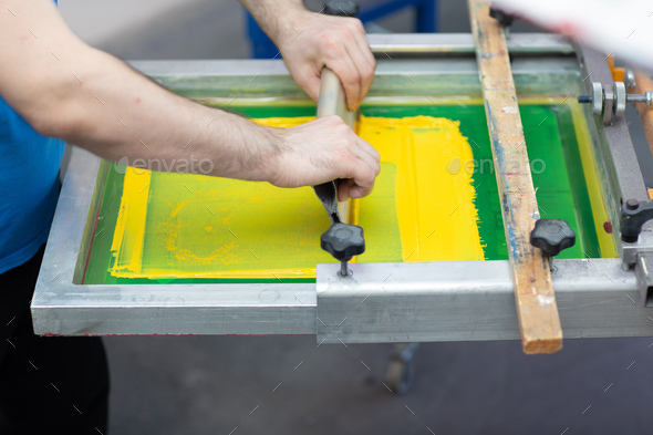 Serigraphy silk screen print process at clothes factory. Frame ...