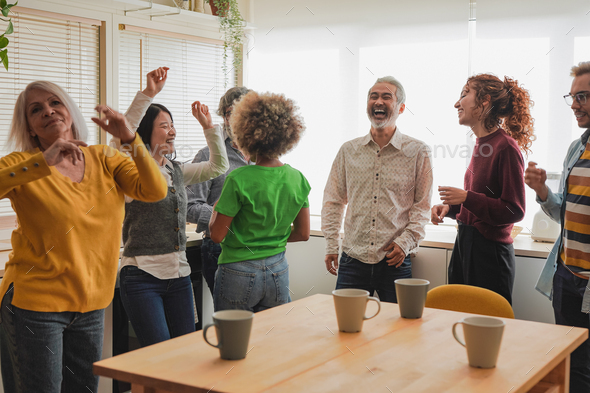 Happy diverse multi generational people dancing together in the kitchen ...