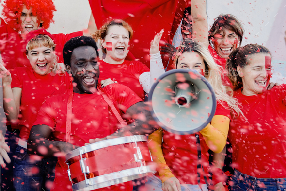 Multiracial sport football fans celebrate red team victory with ...
