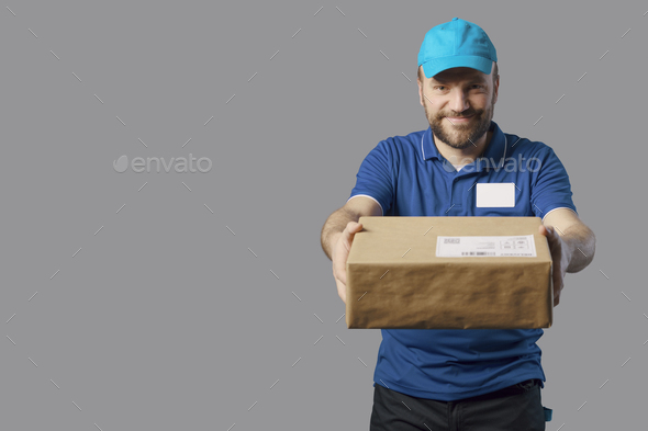 Professional delivery man holding a box Stock Photo by stockasso ...