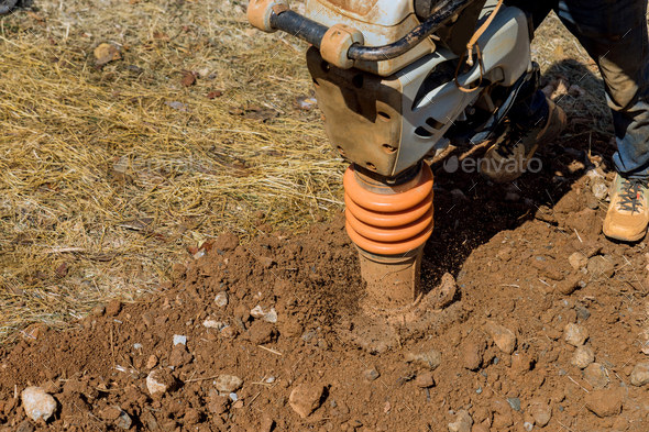 The vibratory plate of the tamping machine compactor tool jumps as a ...