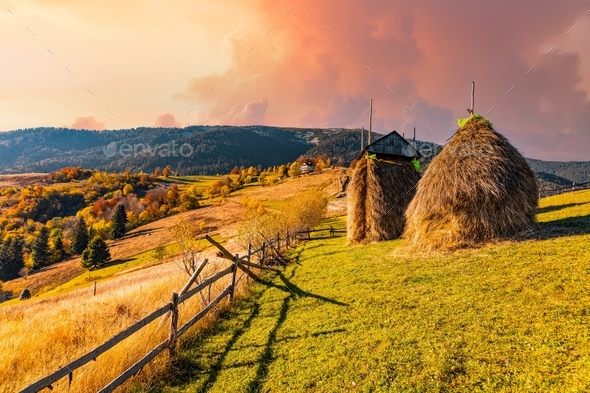 Haystack under wooden roof built behind fence in highland Stock Photo ...