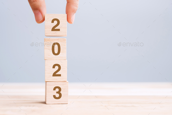 2023 block over 2022 and 2021 wooden building on table background ...