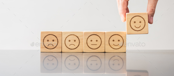 Man hand holding emotion face block. Customer choose Emoticon for user ...