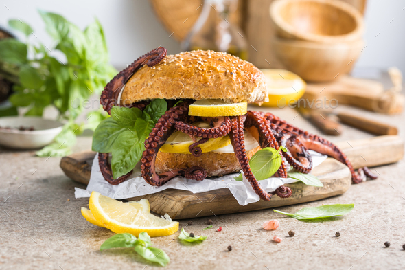 Big burger with octopus and lemon. Large sandwich stuffed with seafood ...