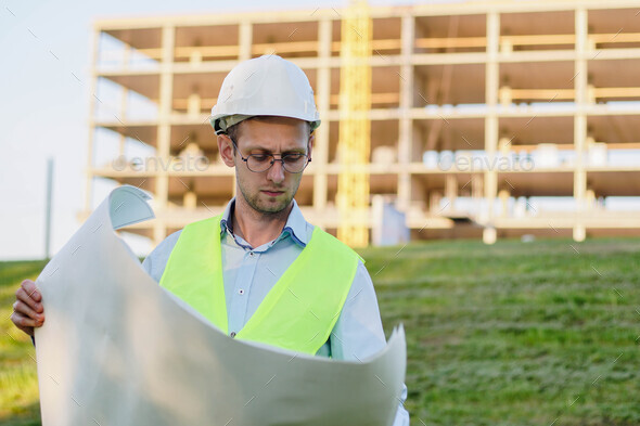 Civil Engineering wearing white helmet on construction site looking at ...