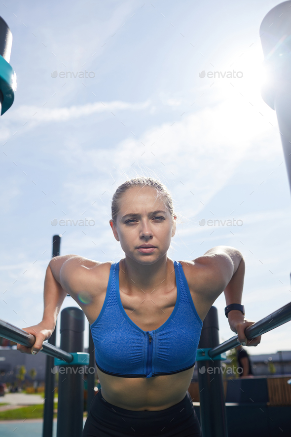 Strong woman keeping body on parallel bars Stock Photo by Media_photos