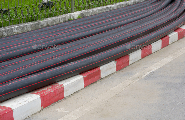 Pile of many HDPE pipes conduit on footpath for underground electrical ...