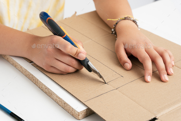 Woman's hands doing crafts cutting cardboard with a cutter Stock Photo ...