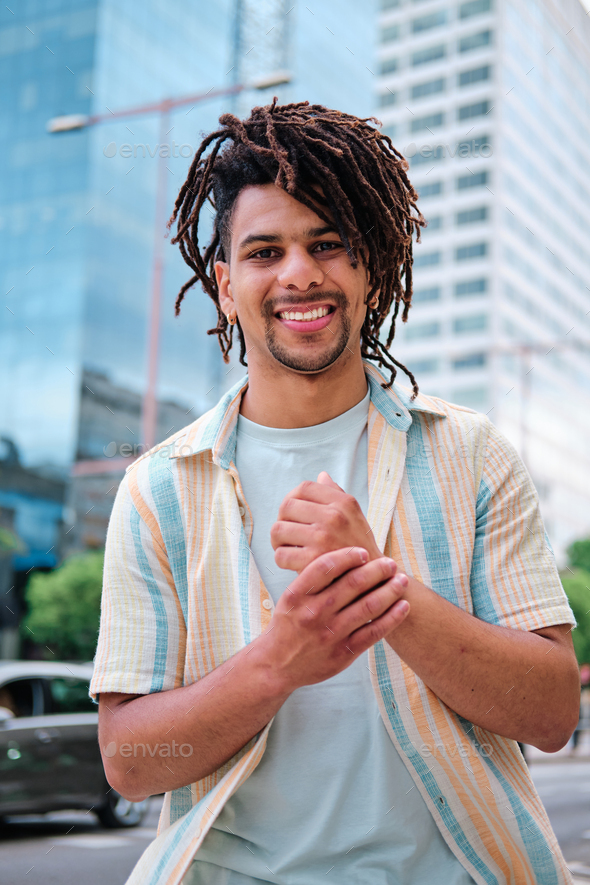 portrait of a young latin man surrounded with modern city buildings ...