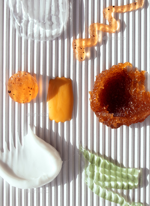 smears samples of various cosmetic textures on a light texture ...