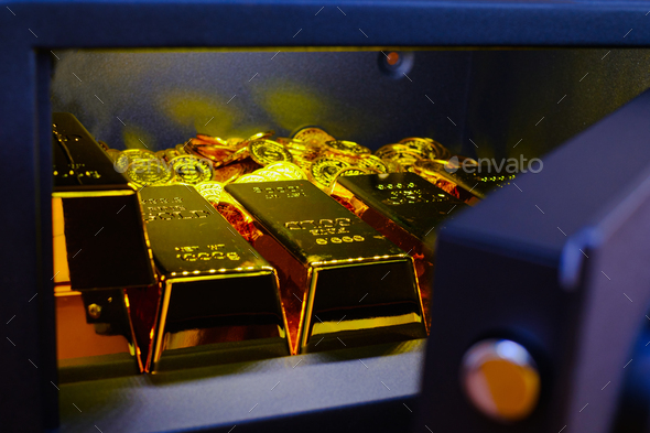 Steel safes box full of coins stack and gold bar on the wooden table ...