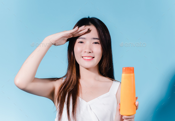 Charming asian beauty woman hold sun cream with sun protection uv or ...