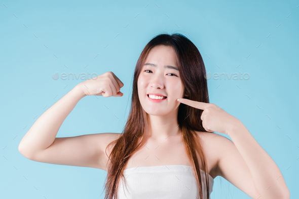 Asian woman smiling show gesture have strong teeth on the blue ...