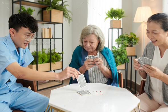 Nurse Playing Cards with Patients Stock Photo by DragonImages | PhotoDune