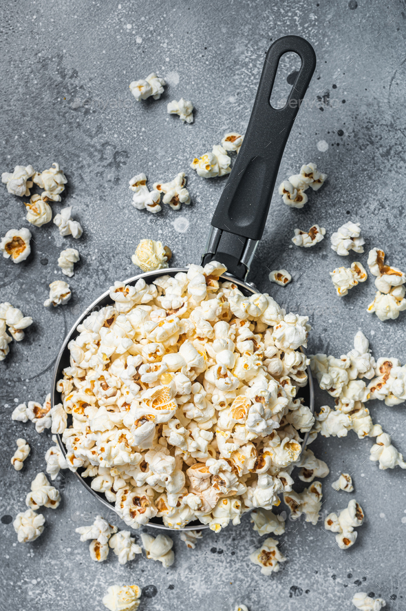 Cooking salted popcorn in a skillet. Gray background. Top view Stock ...