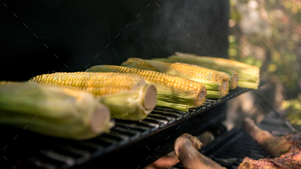Chef cooking BBQ with a corn on the cob on grilled. Delicious corns on ...