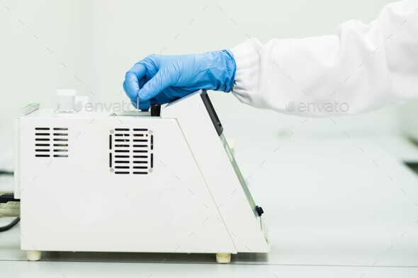 Chemist's hand is insert capillary tube to melting point testing ...