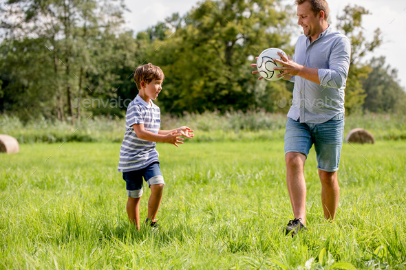Father and daughter watching bugs in the grass using magnifying glass ...