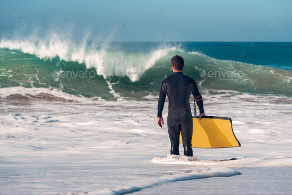 surfer with board watching big wave from the shore Stock Photo by Raul ...