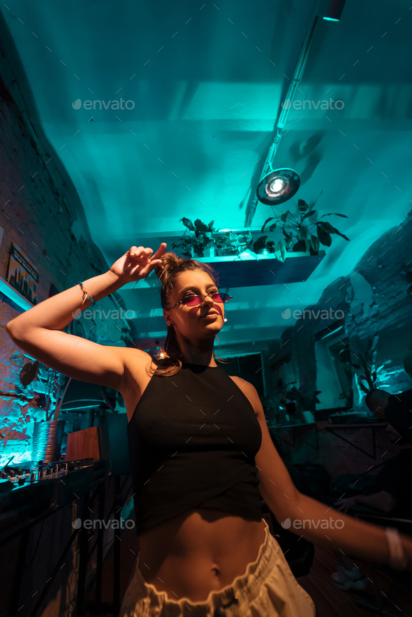 Beautiful female DJ dancing to techno in a small club Stock Photo by ...