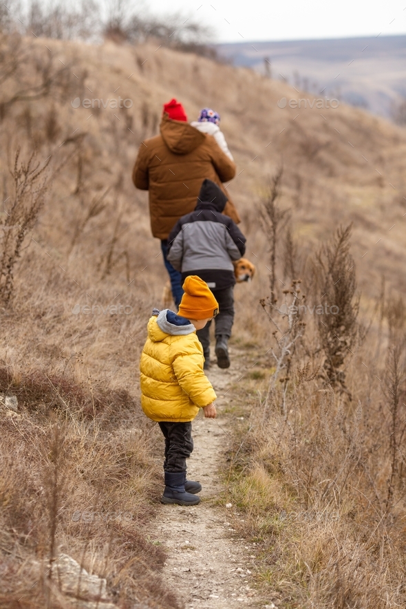 Children follow their father in the wild way Stock Photo by levinajuli