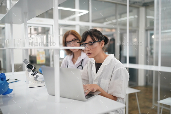 Medic working with microscope at the laboratory Stock Photo by FoToArtist_1