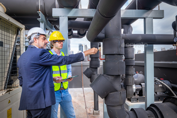 Manager and Engineers holding blueprint project under checking building ...