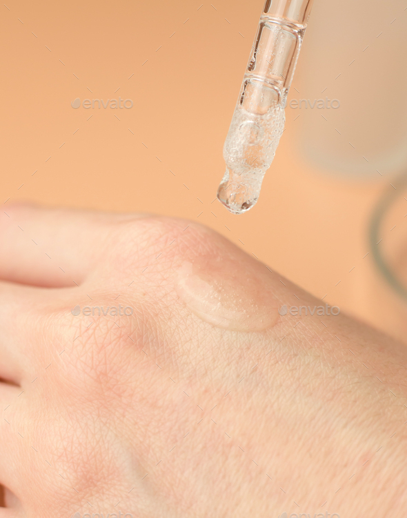 Transparent gel on a female hand. A woman applies a moisturizing gel ...