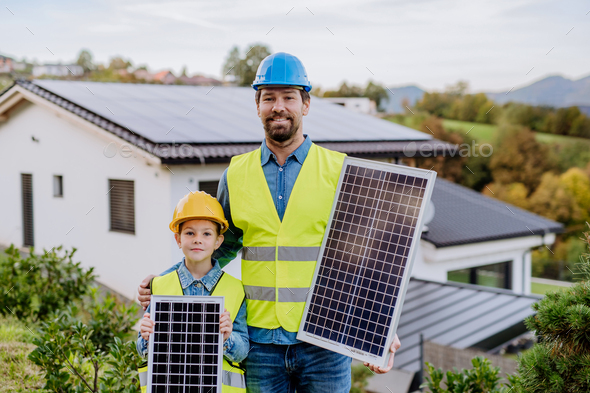 Smiling handyman solar installer standying with his daughter and ...