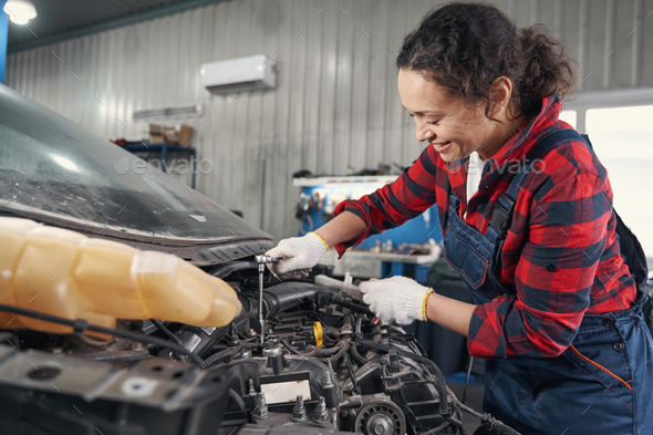 Positive delighted master repairing car in garage Stock Photo by Iakobchuk