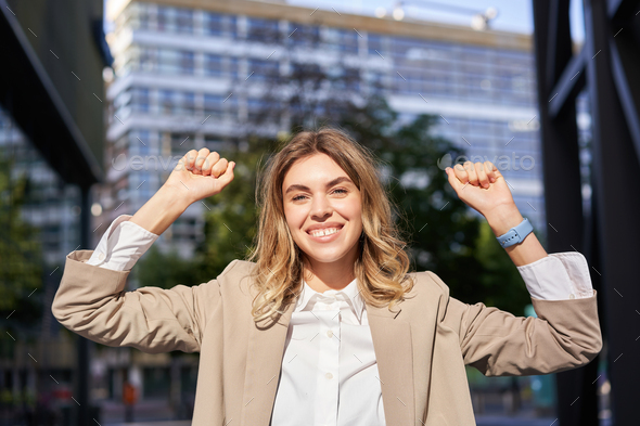 Happy smiling saleswoman in beige suit, celebrates her achievement ...
