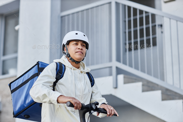 Food Delivery Worker using Scooter Stock Photo by seventyfourimages