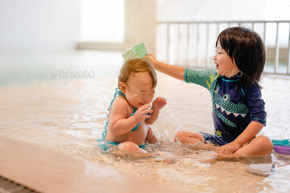 Two Kids in swimming pool. Children swim indoors.Child during vacation ...