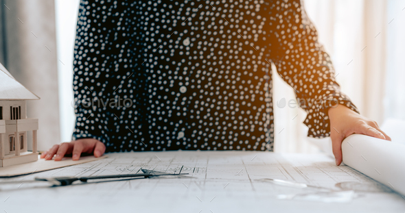 Close-up,female architect viewing Blueprint, customer factory ...