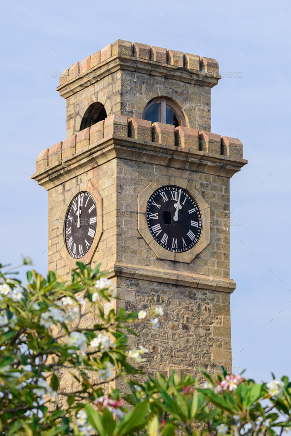 The Galle Clock tower close-up shot in Galle fort, rise above the trees ...