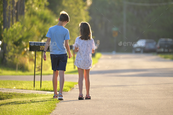Back view of two young teenage children, girl and boy, brother and ...