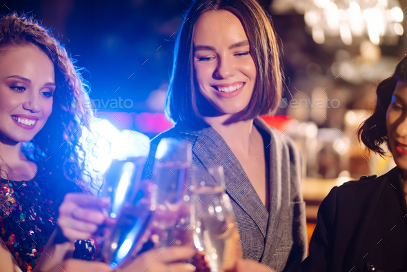 Cheering and drinking cocktails. Group of friends partying in a ...