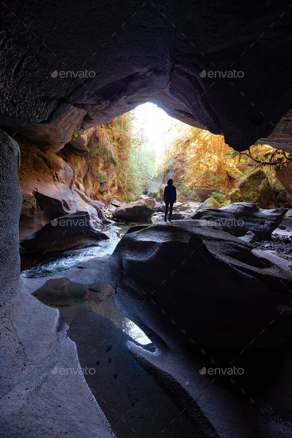 Adventurous woman standing inside a cave. Adventure Travel. Little ...