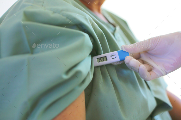Body temperature check with digital thermometer Stock Photo by FoToArtist_1