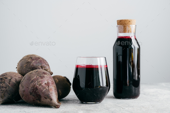 Fresh bright beetroot juice in glass bottle, raw red beet near ...