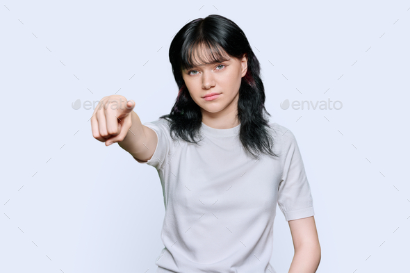 Displeased angry young woman pointing finger at camera, white ...