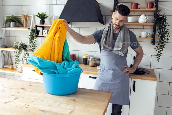 Man doing chores, cleaning the house, sorting laundry Stock Photo by ...