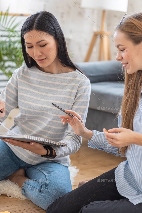 Two young women learning language or working on the university project ...