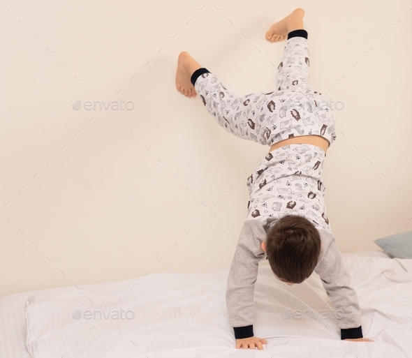 Child boy stand on his hand on the bed at the morning. Morning ...