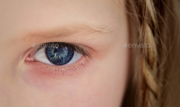 Child's blue eye look close up. Little kid girl watching at the camera ...