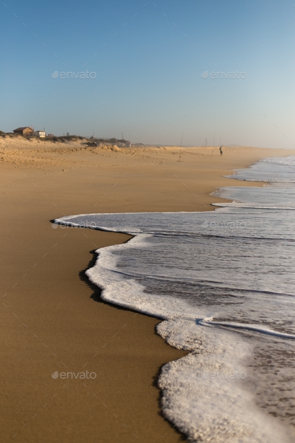 Waves washing over the sand at golden hour Stock Photo by StudioAour