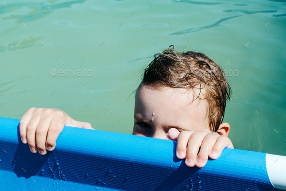 a five-year-old boy swims in the pool Stock Photo by JoesBoilingPoint